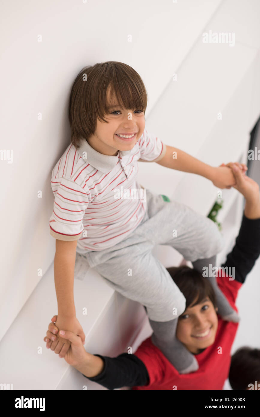 happy young boys having fun and posing line up piggyback in new modern ...