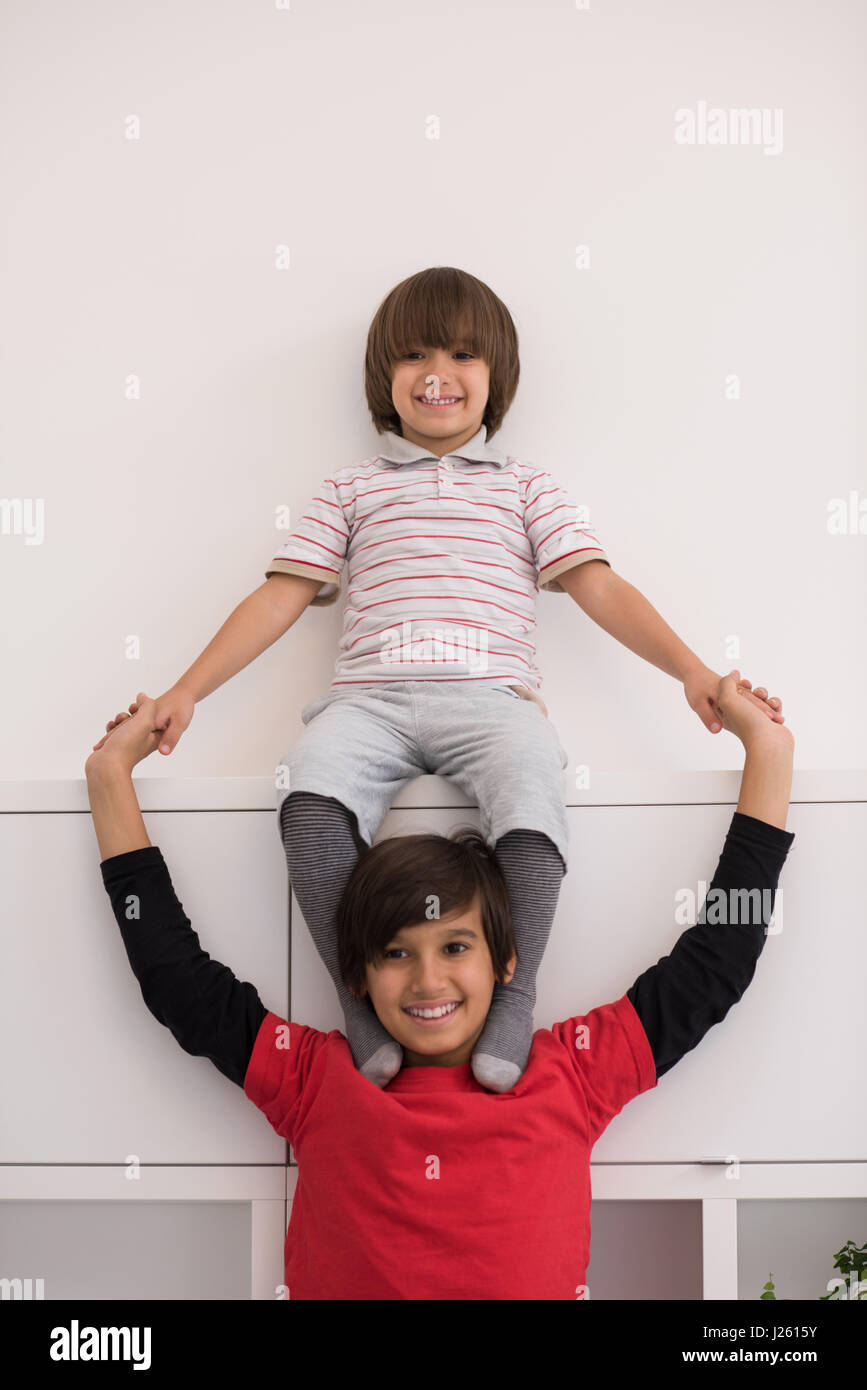 happy young boys having fun and posing line up piggyback in new modern ...
