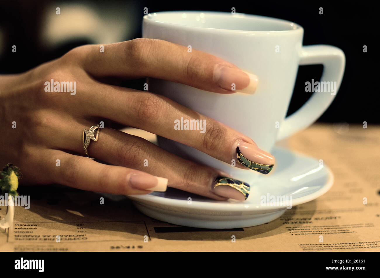 Delicate and beautiful left hand holding the ñup in cafe at the weekend ...