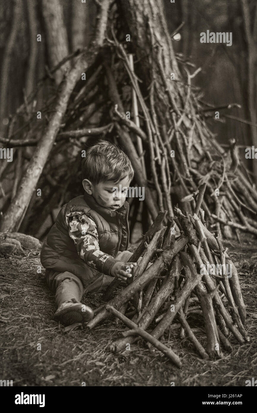 Cute little boy building a wooden shelter Stock Photo - Alamy