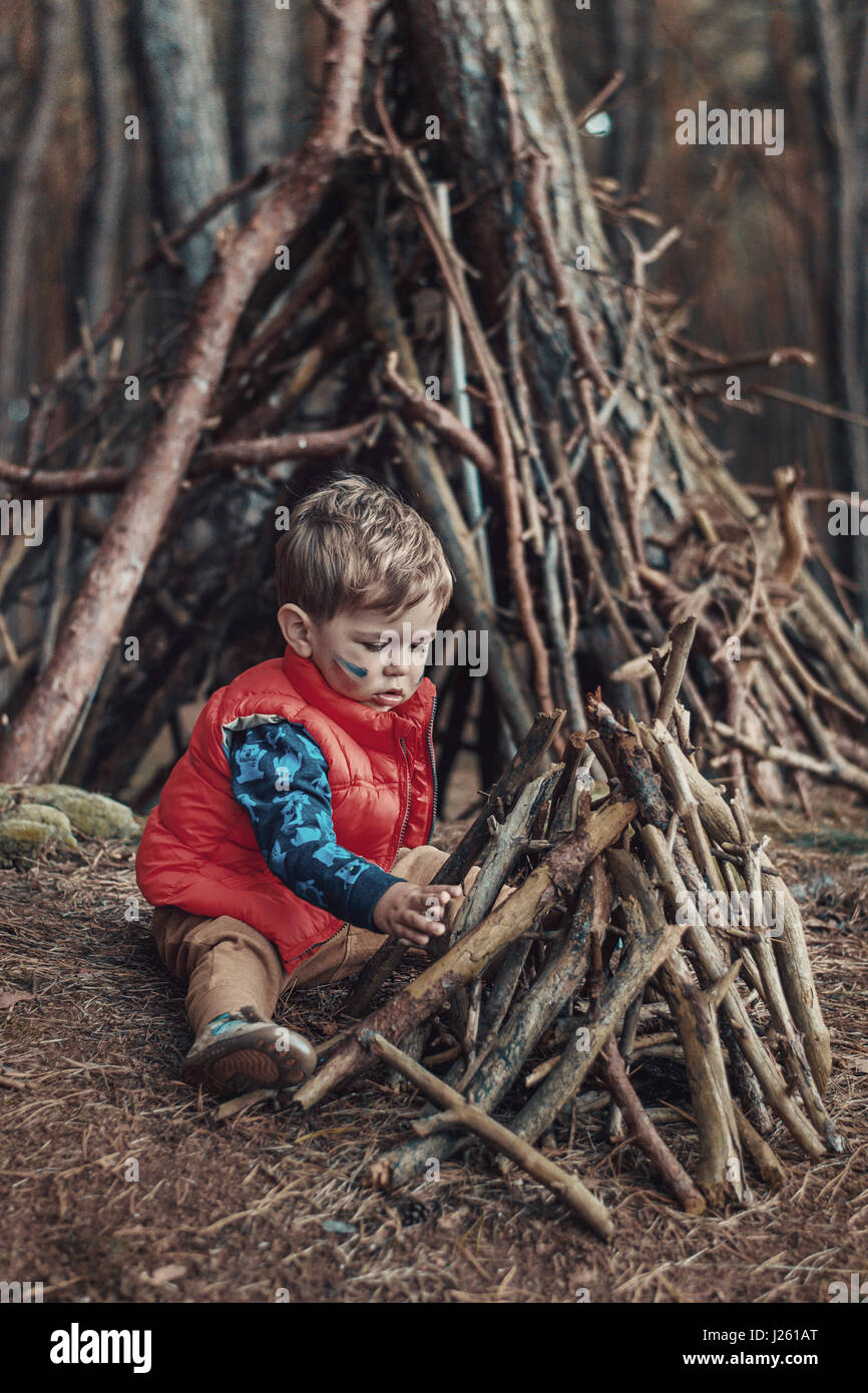 Cute little boy building a wooden hut Stock Photo - Alamy