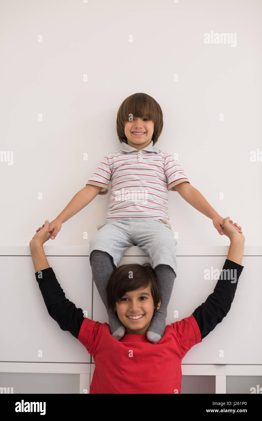 happy young boys having fun and posing line up piggyback in new modern ...