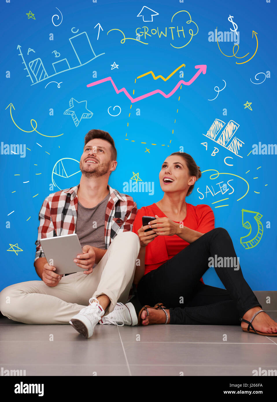 Man and woman sitting with digital devices Stock Photo - Alamy