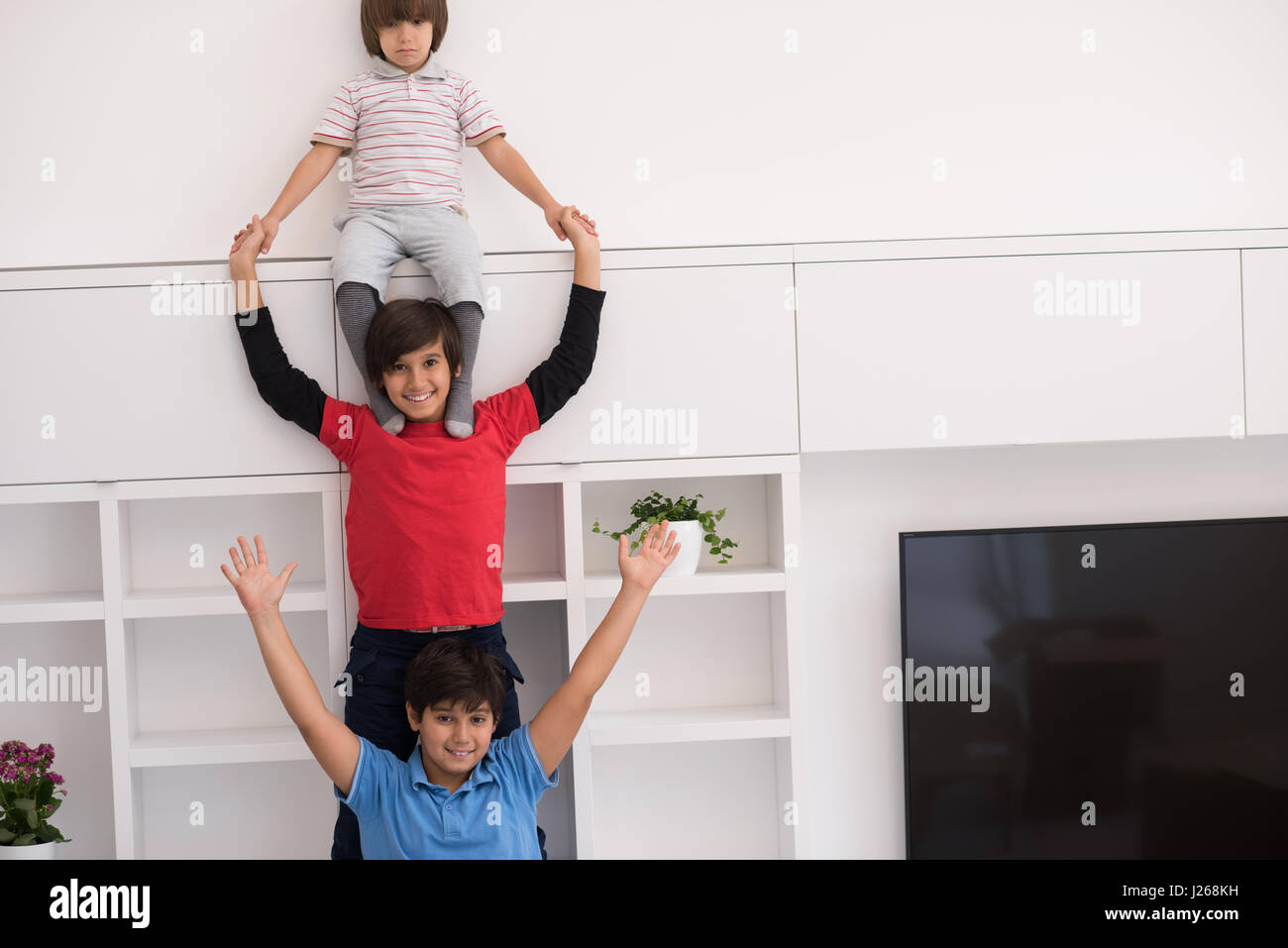 happy young boys having fun and posing line up piggyback in new modern ...