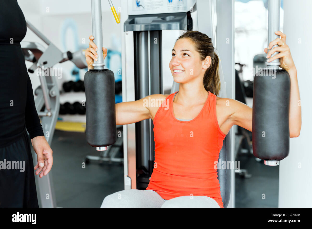 Young male trainer giving instructions to a woman in a gym and being ...