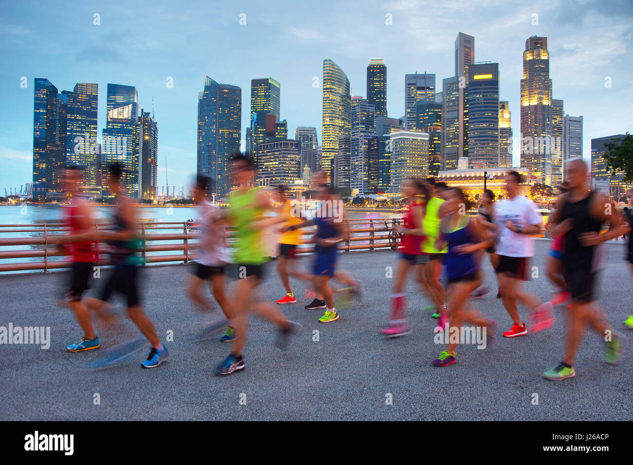 Group of runners on Singapore quayside at twilight Stock Photo - Alamy