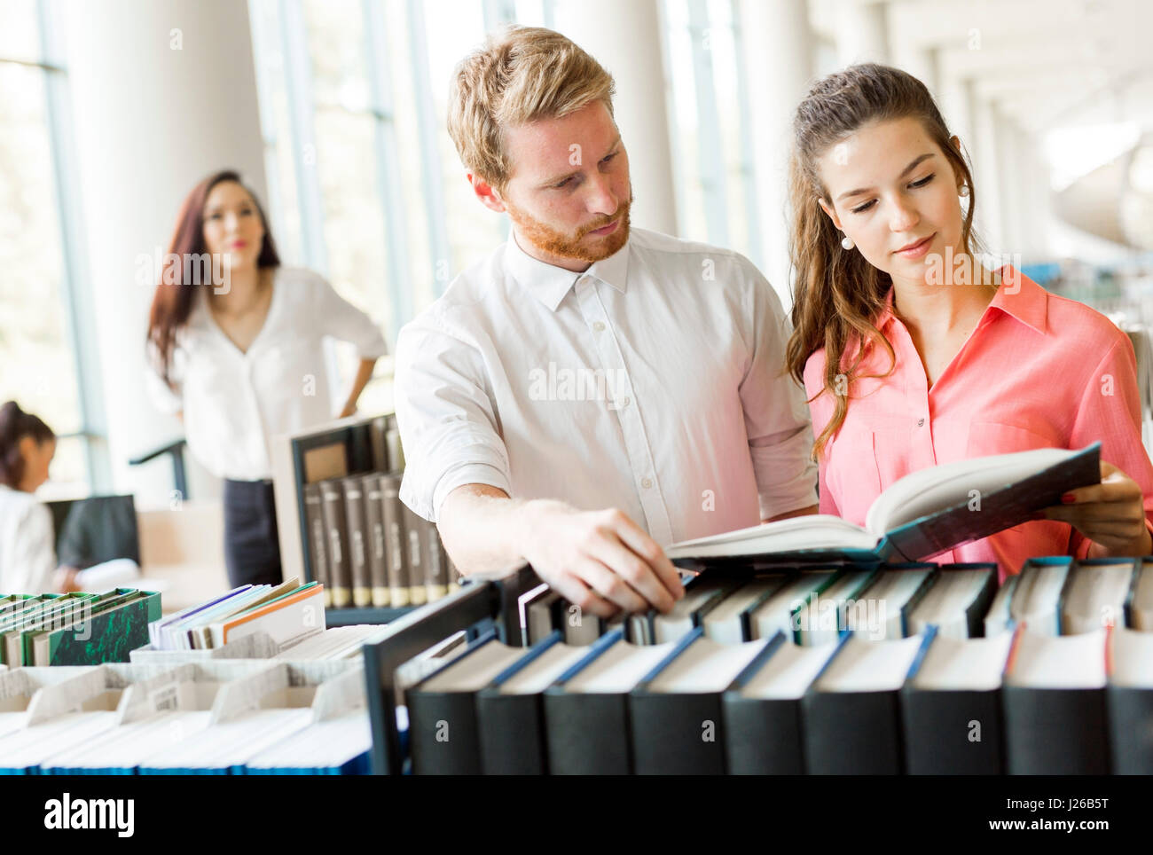 Two smart students reading and studying in library whole searching ...