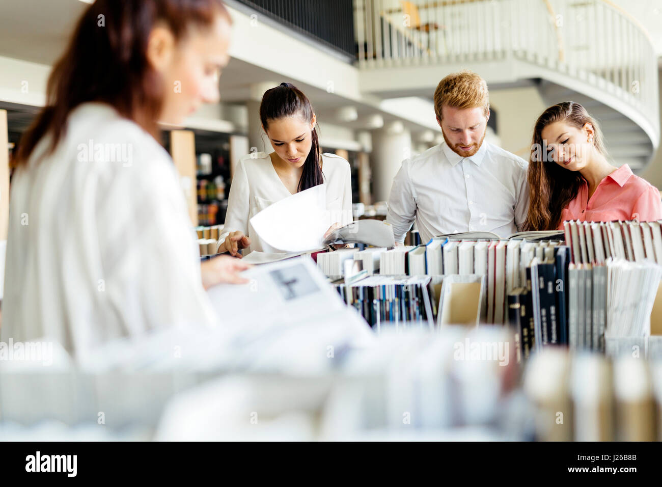 Group of students studying in library and reading books Stock Photo - Alamy