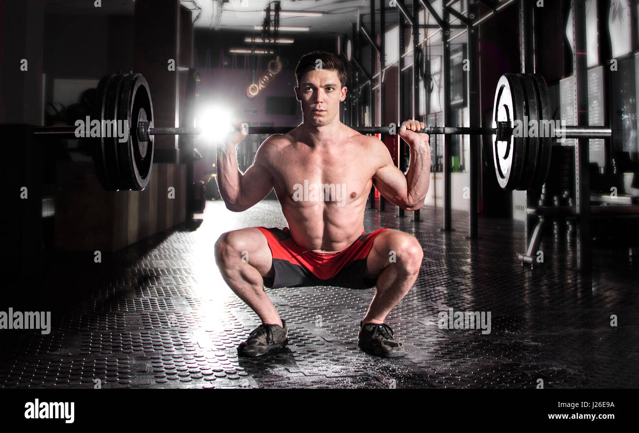 Attractive muscular crossfit athlete doing squat exercise in mo Stock ...