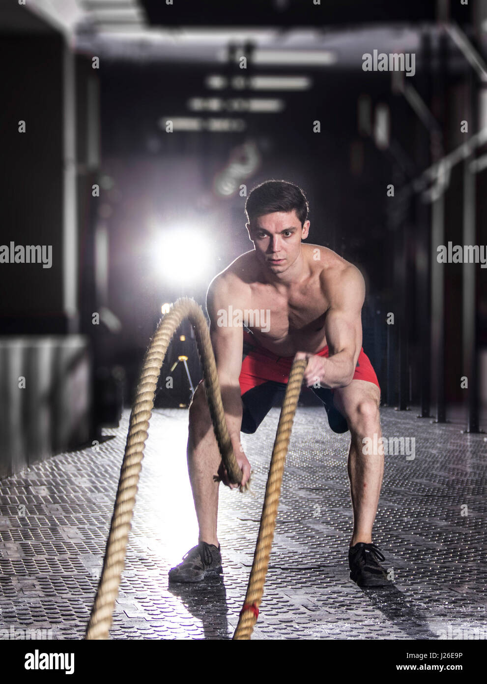 Muscular athlete with battle rope battle ropes exercise in the f Stock ...