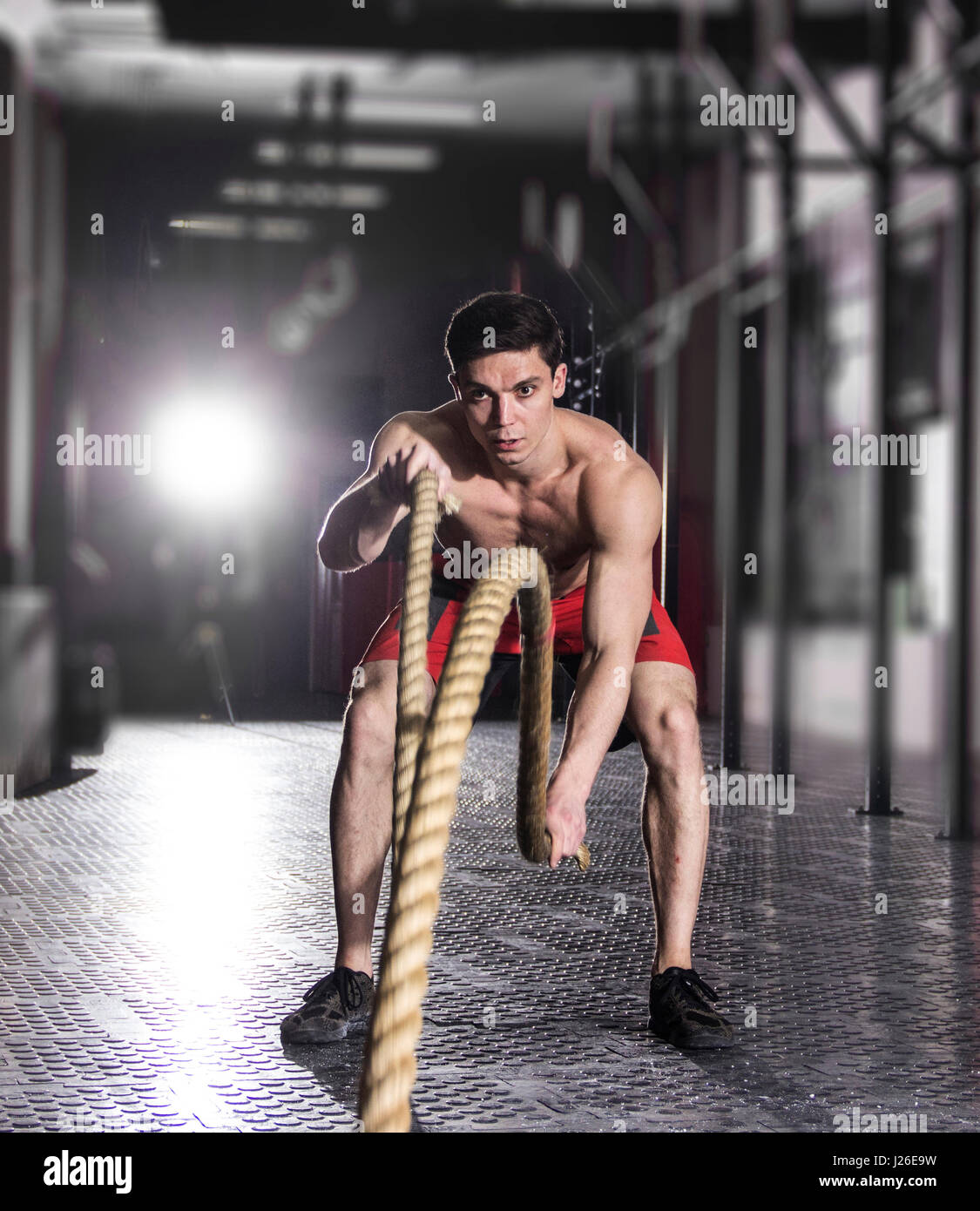 Muscular athlete with battle rope battle ropes exercise in the f Stock ...