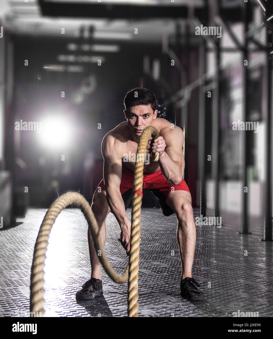 Muscular athlete with battle rope battle ropes exercise in the f Stock ...