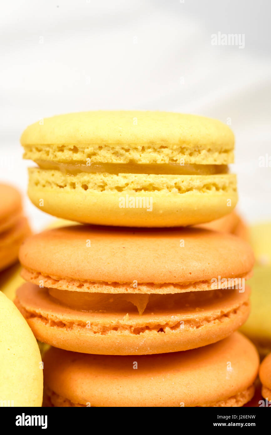 Stack of orange and yellow macaroon biscuits isolated on white Stock ...