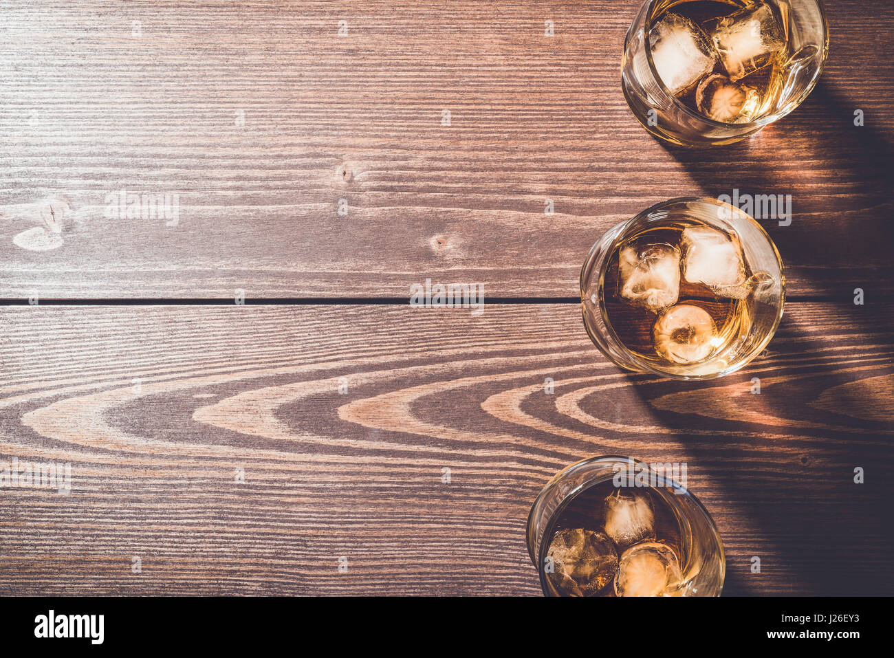 Glasses of whiskey on an old wooden table Stock Photo - Alamy