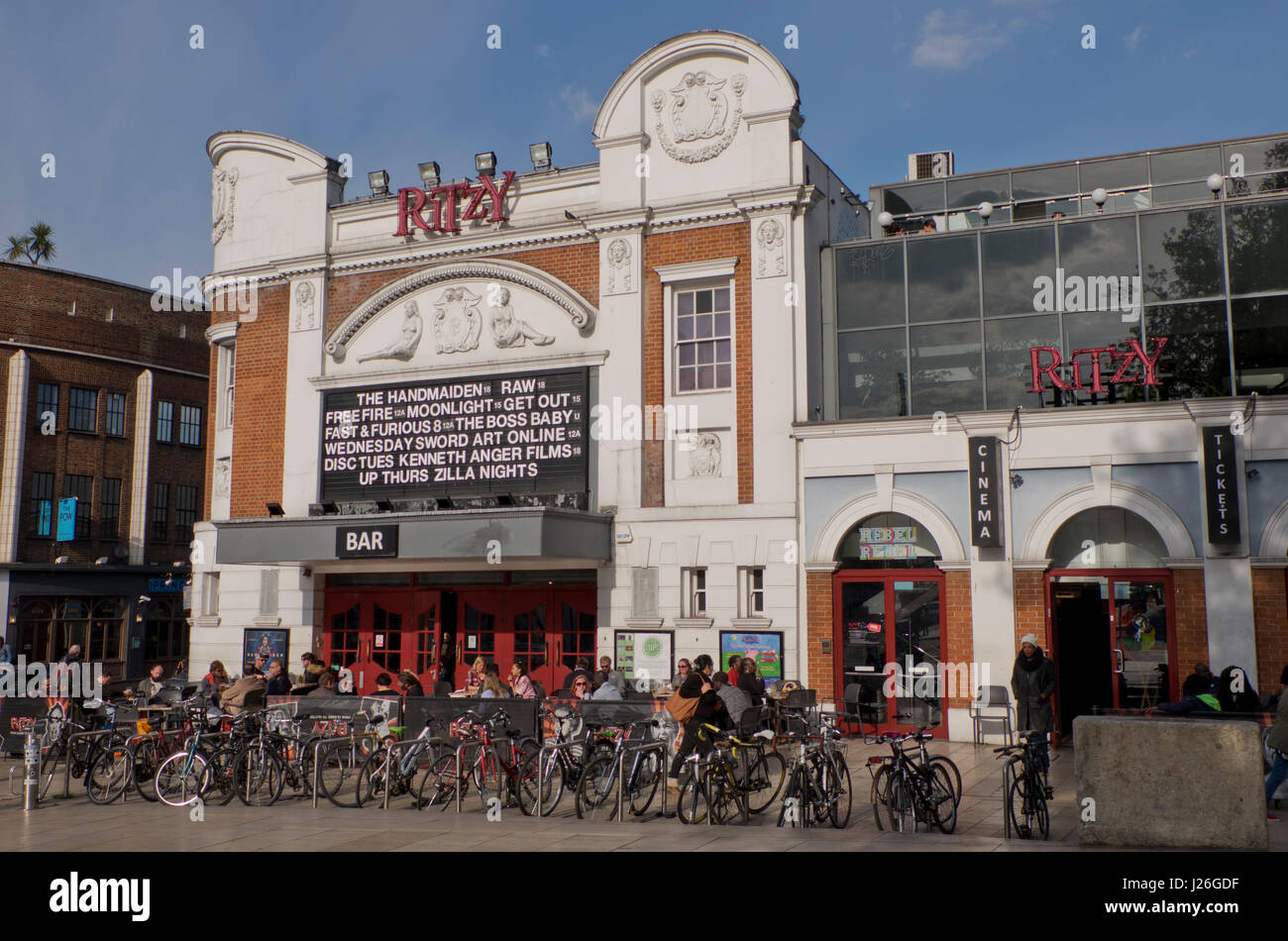 People sit outside at the bar of the Art Deco Ritzy cinema in Brixton ...