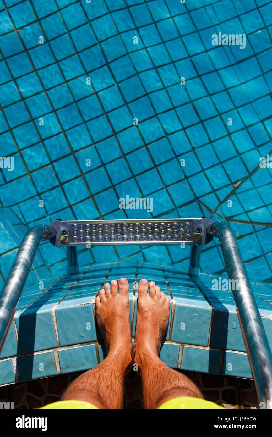 Man standing on pool ladder with clean water Stock Photo - Alamy