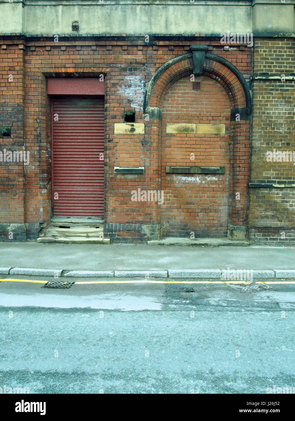 old abandoned brick building with shutter and bricked up doorway and ...