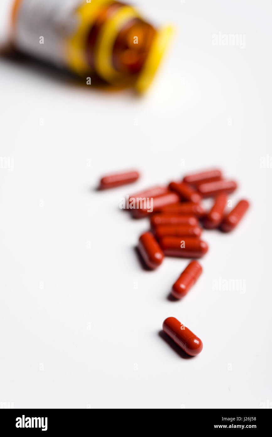Red pills and medicines over a white board with optical bokeh effect ...