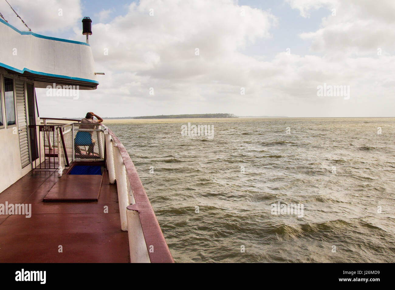 Man waiting alone on the ferry boat fore deck until it reaches its ...