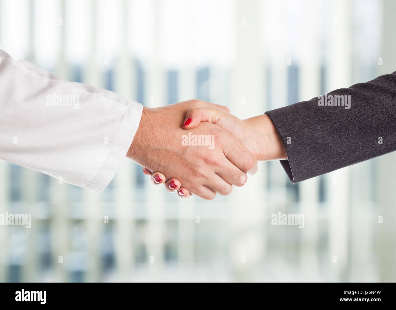 Doctor and female patient handshake Stock Photo - Alamy
