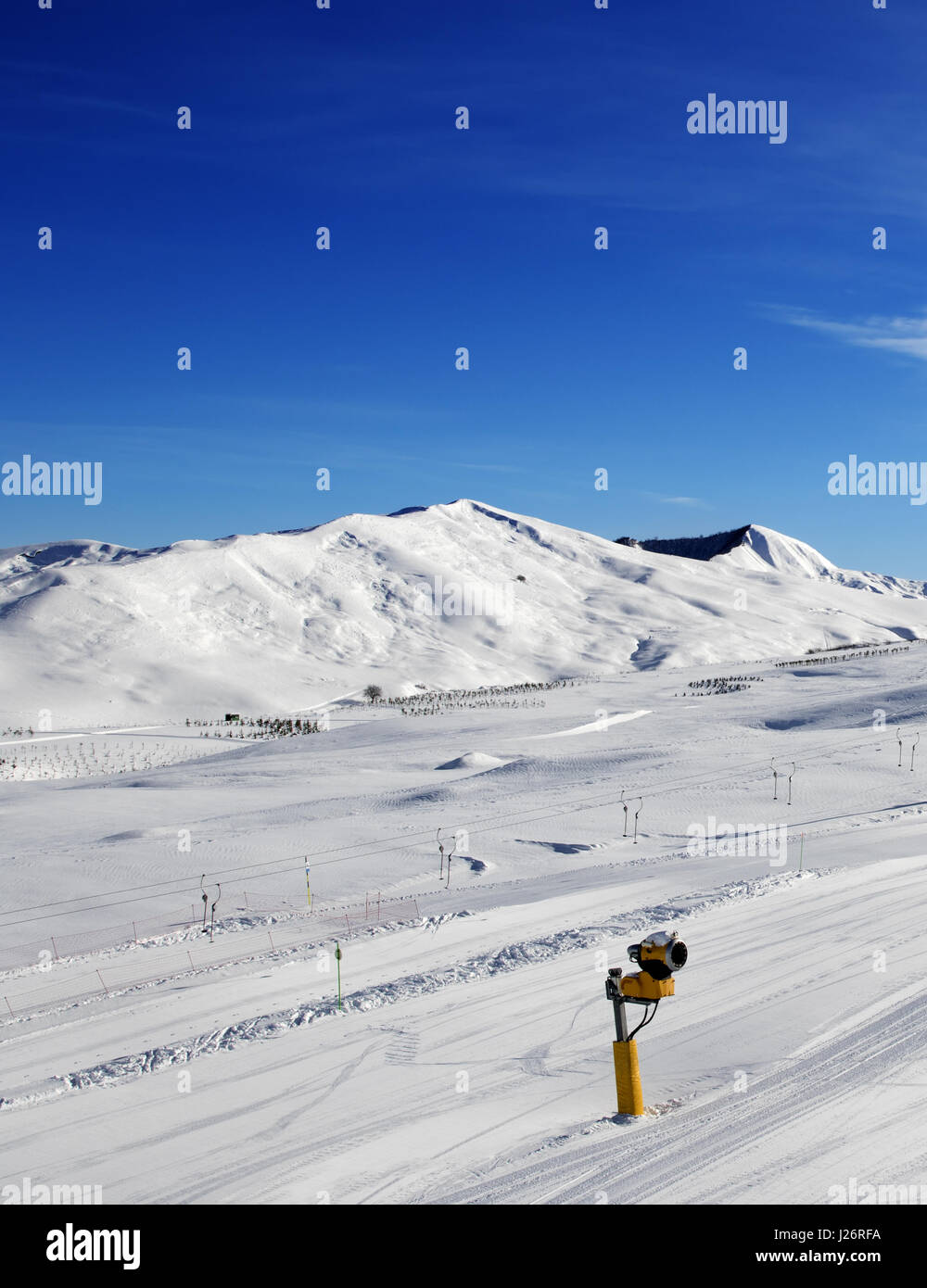 Ski slope with snowmaking at sun day. Greater Caucasus, Mount Shahdagh ...
