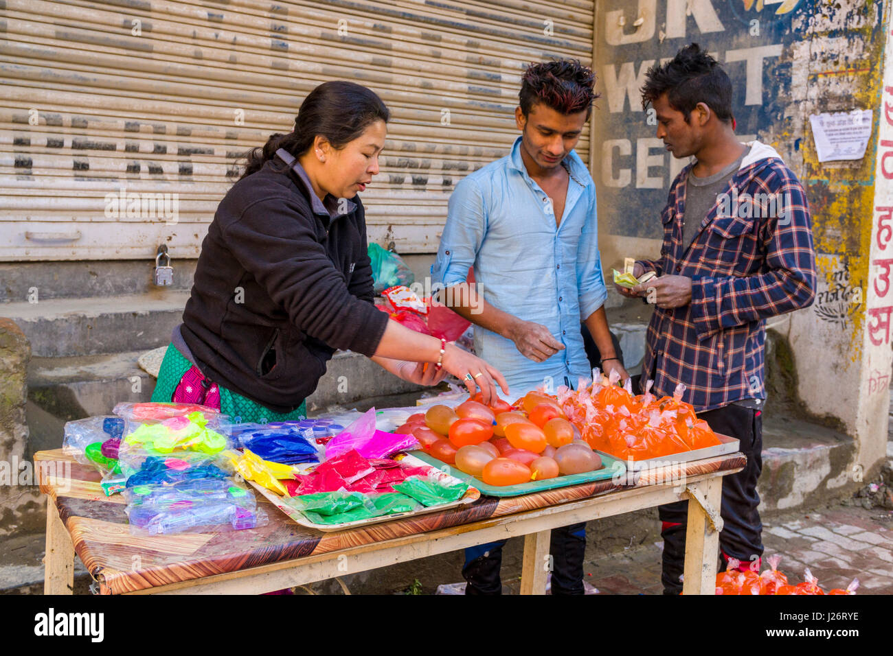 A woman is selling color powder and water bombs for the Holi Festival ...