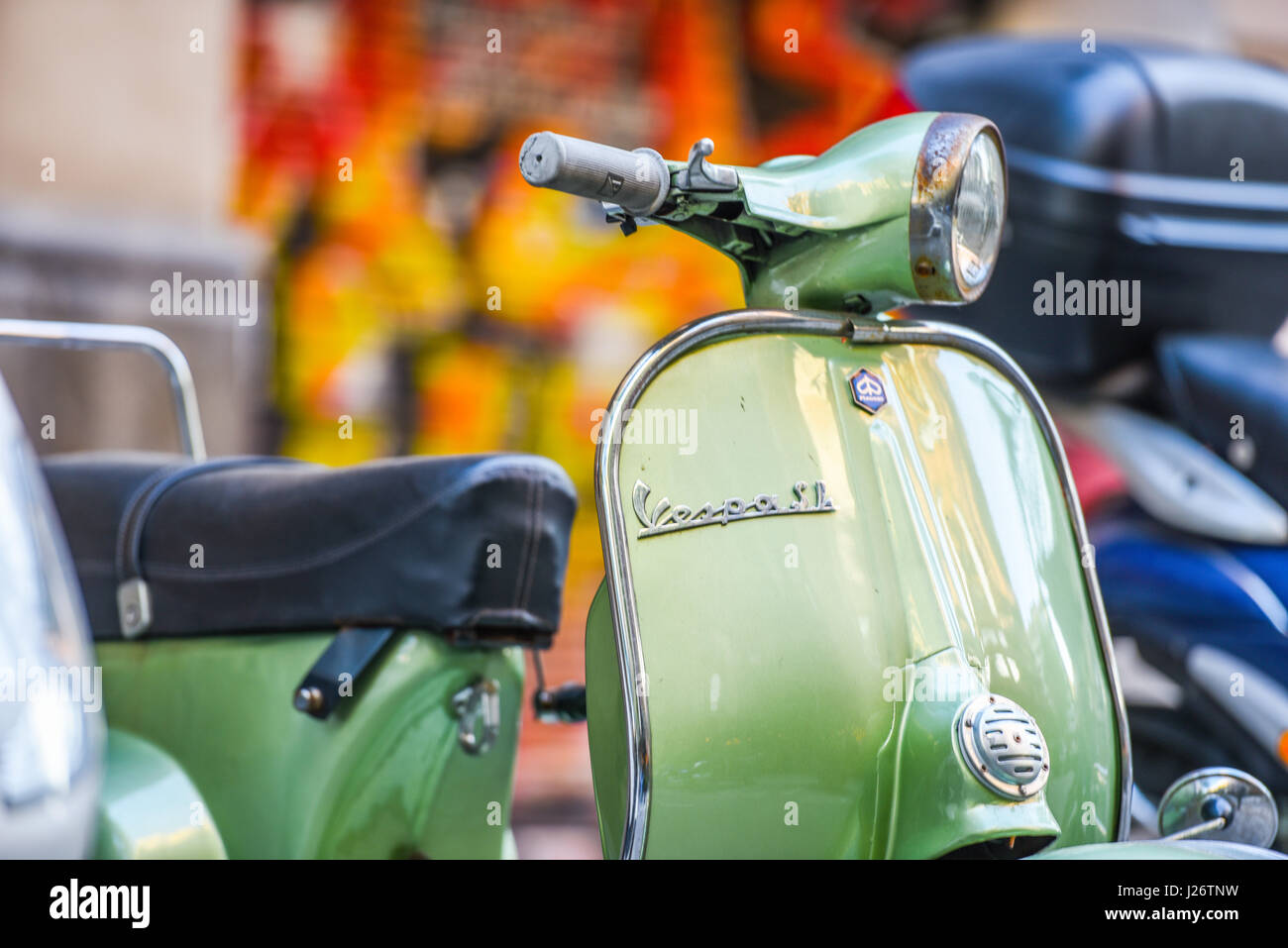Shiny polished and clean beautiful scooters stand parked on a sidewalk ...