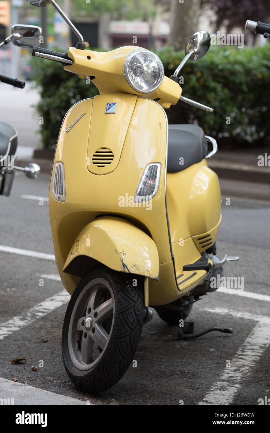 Shiny polished and clean beautiful scooters stand parked on a sidewalk ...