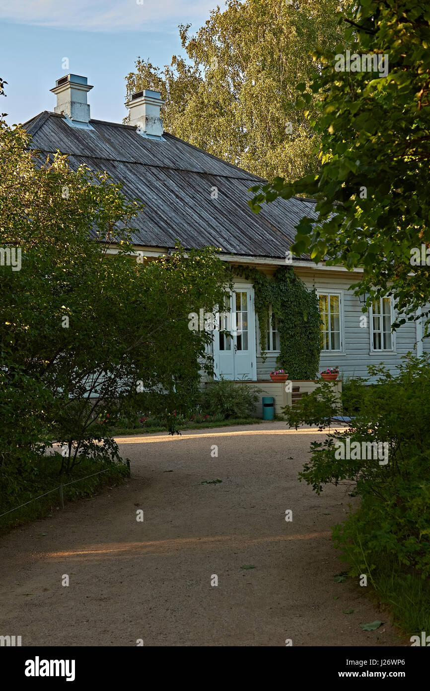 Rural house in the park.A wooden one-storey rural house among trees ...