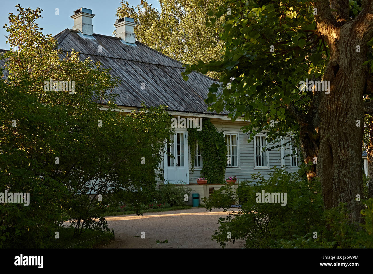 Rural house in the park.A wooden one-storey rural house among trees ...