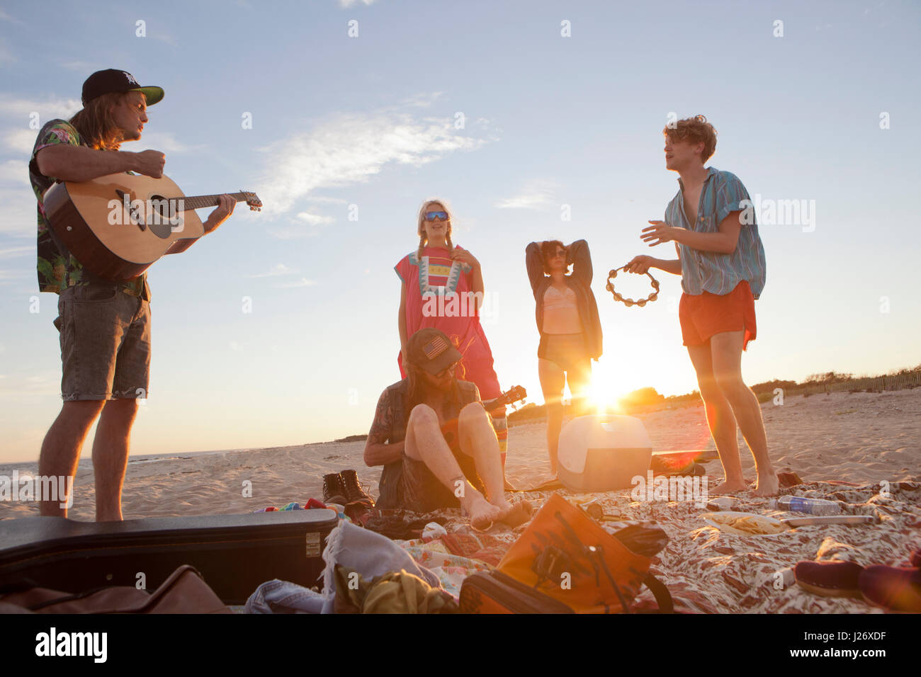 Friends playing music together on a beach Stock Photo - Alamy