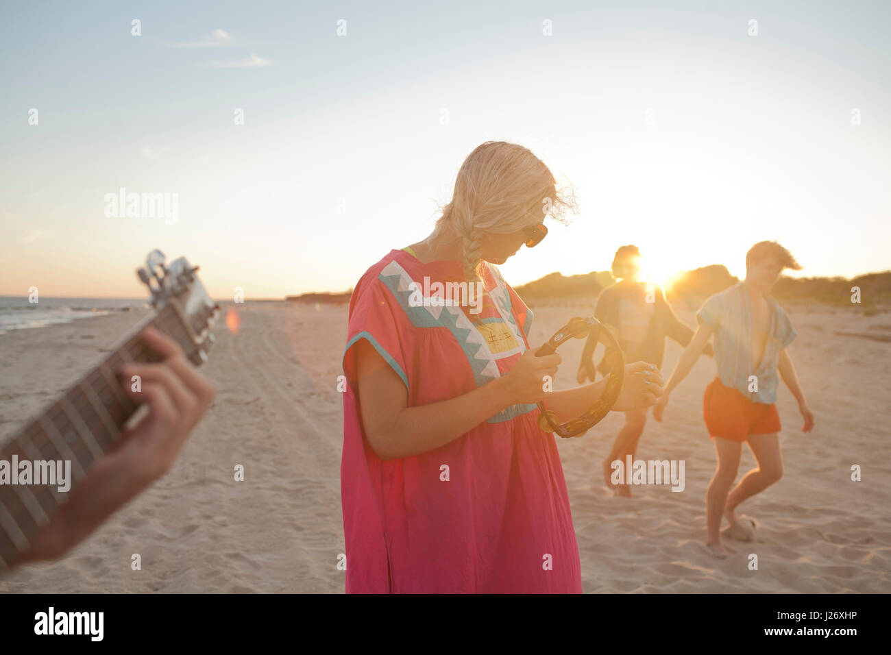 Friends playing music together on a beach Stock Photo - Alamy