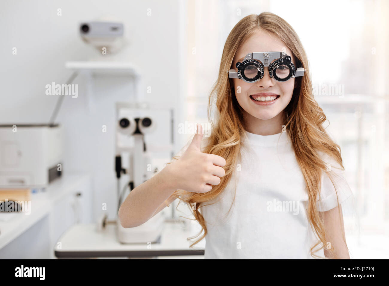 Cool positive girl trying different lenses Stock Photo - Alamy