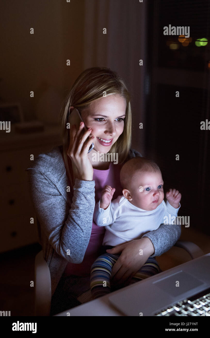 Mother with son in the arms, making phone call Stock Photo - Alamy