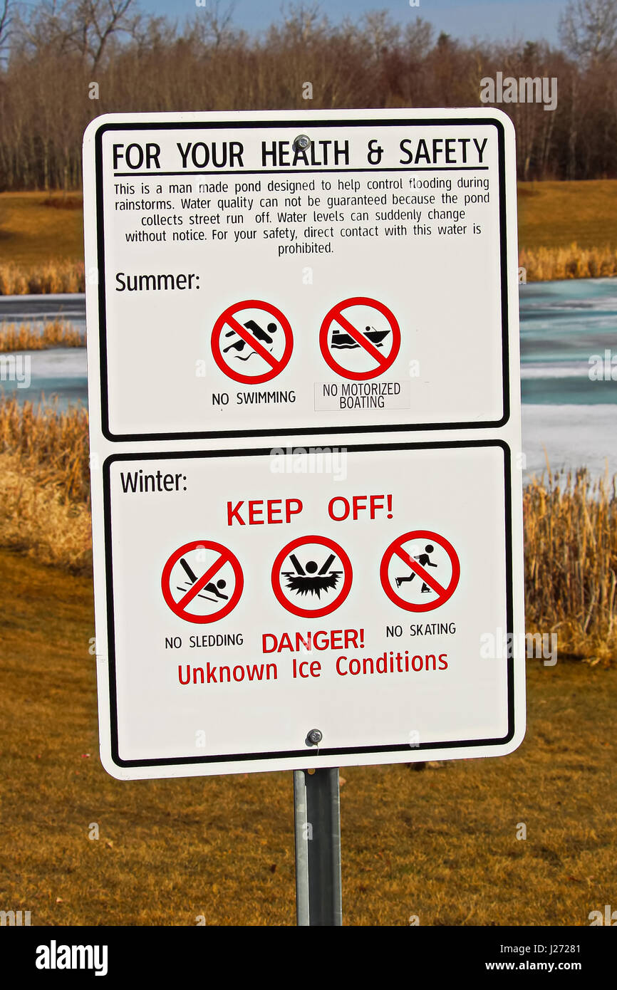 Warning signs around storm drainage pond Stock Photo - Alamy