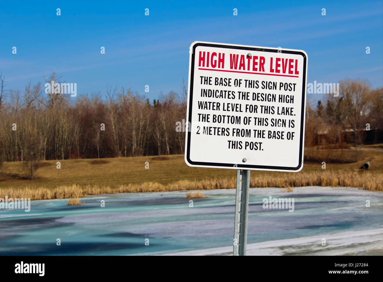 High water level sign along a storm drainage pond Stock Photo - Alamy