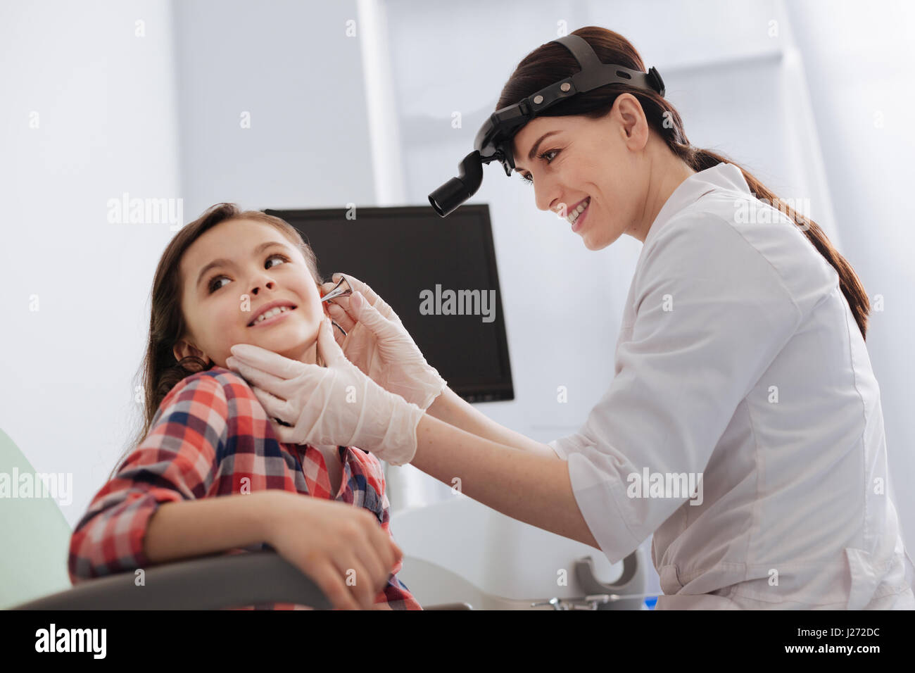 Smiling ENT doctor examining little ear Stock Photo - Alamy