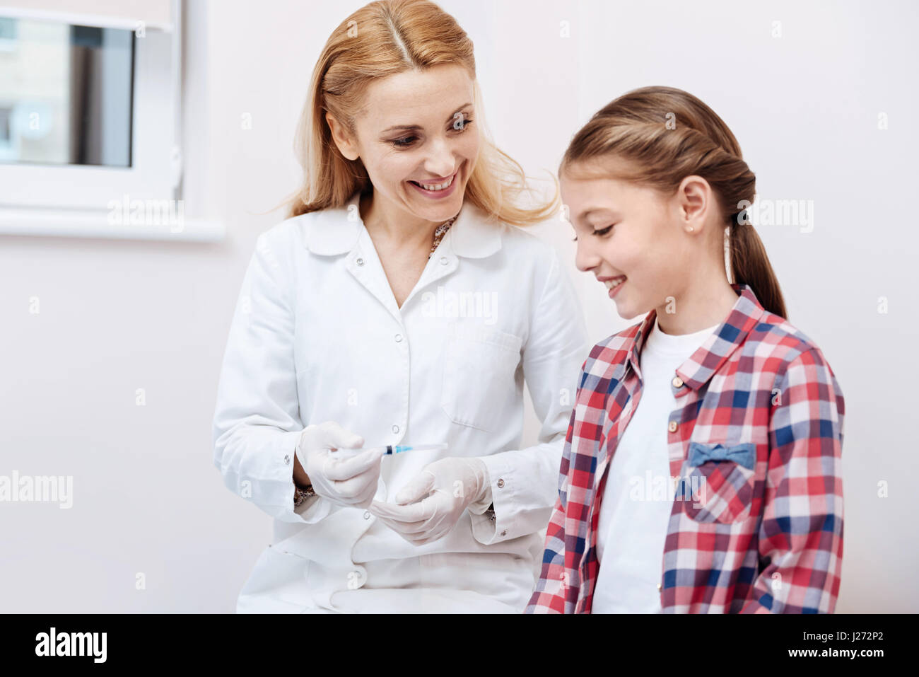 Smiling female doctor holding syringe Stock Photo - Alamy