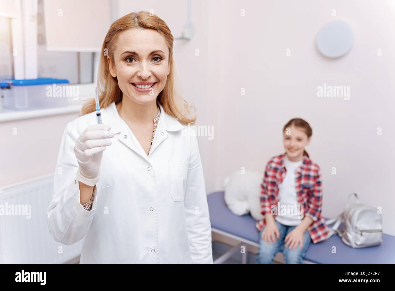 Portrait of nice nurse that holding syringe in right hand Stock Photo ...