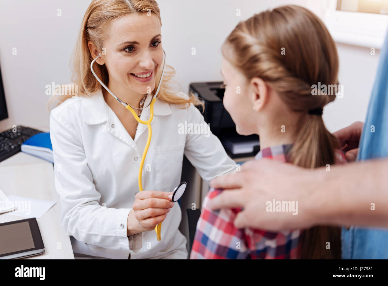 Delighted young doctor checking health position Stock Photo - Alamy