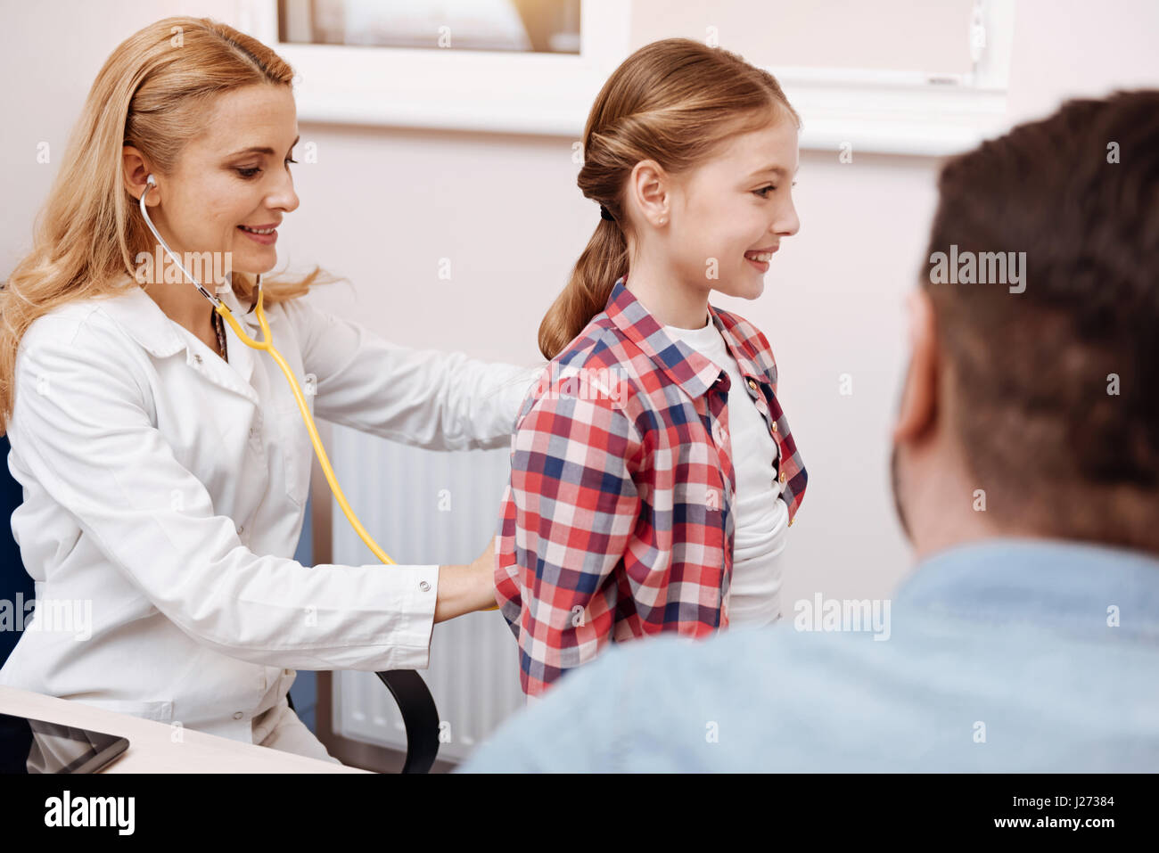 Smiling girl turning with back to her nurse Stock Photo - Alamy