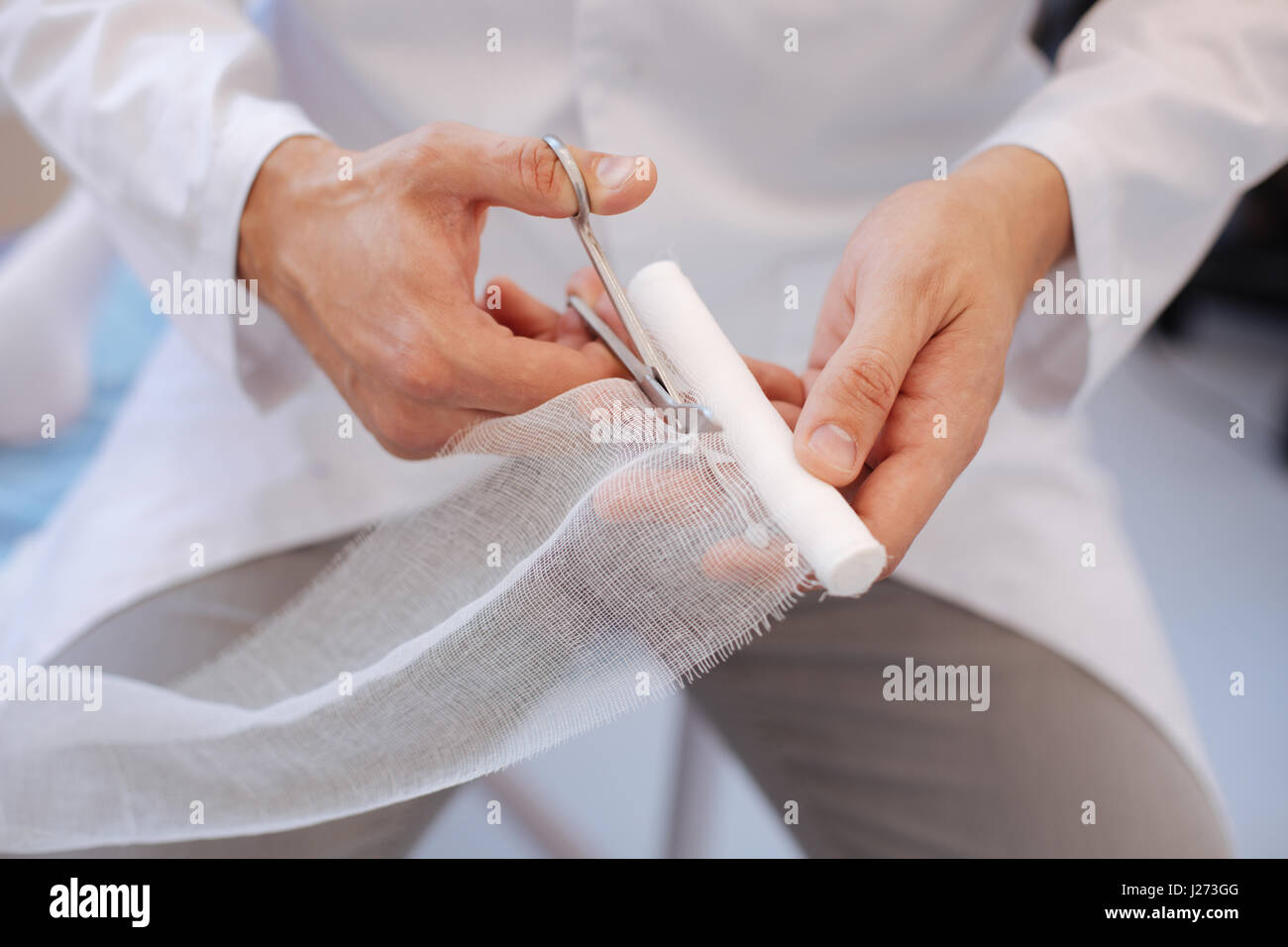 At the hospital. Close up of a medical bandage being cut into pieces by ...