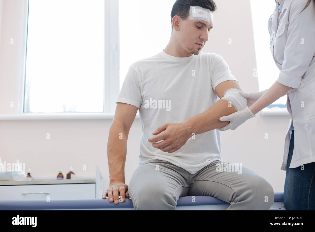 Cheerless wounded man looking at his injury Stock Photo - Alamy
