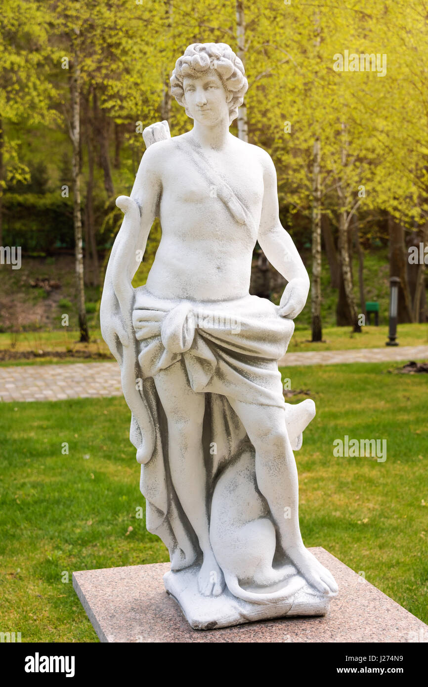 Sculpture in classic style. Statue of a man hunter with bow and dog ...