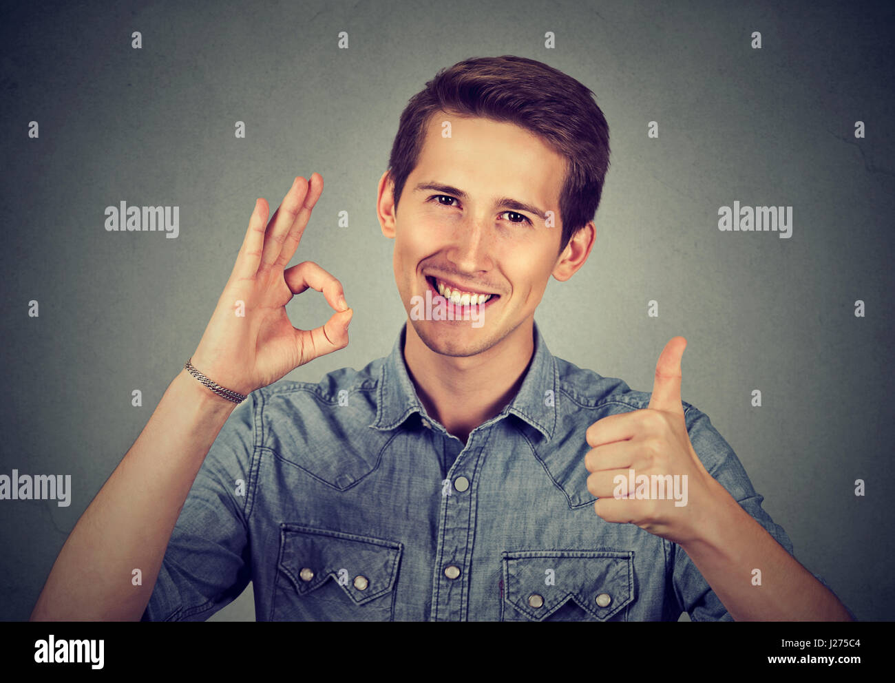 Enthusiast man with thumbs up and ok hand gesture Stock Photo - Alamy