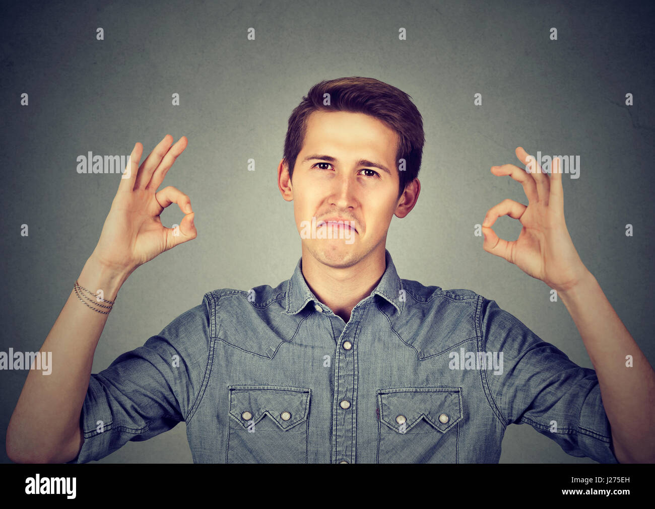 Satisfied man gesturing Ok sign Isolated on gray background Stock Photo ...