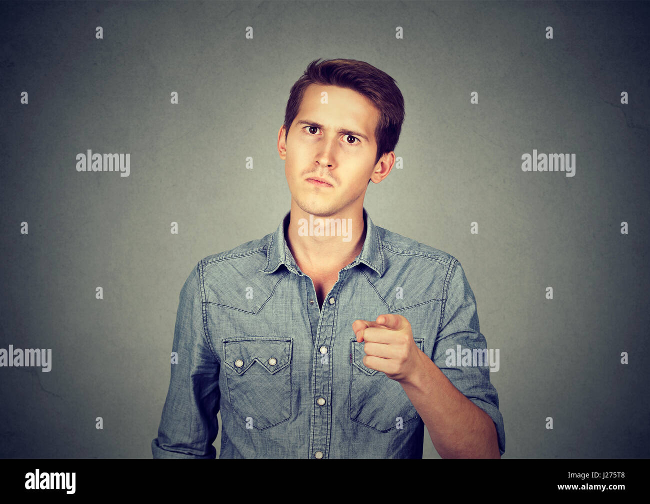 Portrait of a angry young man pointing finger at you camera gesture ...
