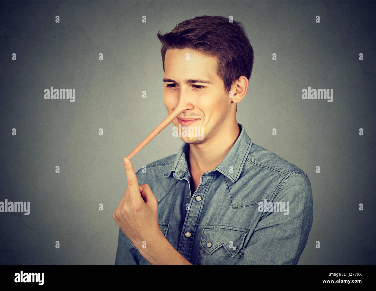 Man with long nose isolated on grey wall background. Liar concept ...