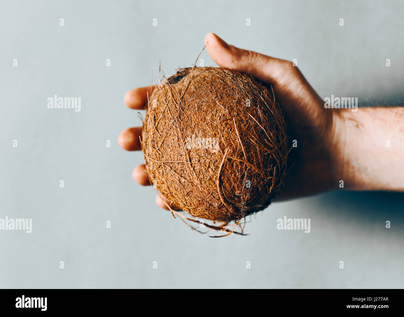 Coconut held in hand Stock Photo - Alamy