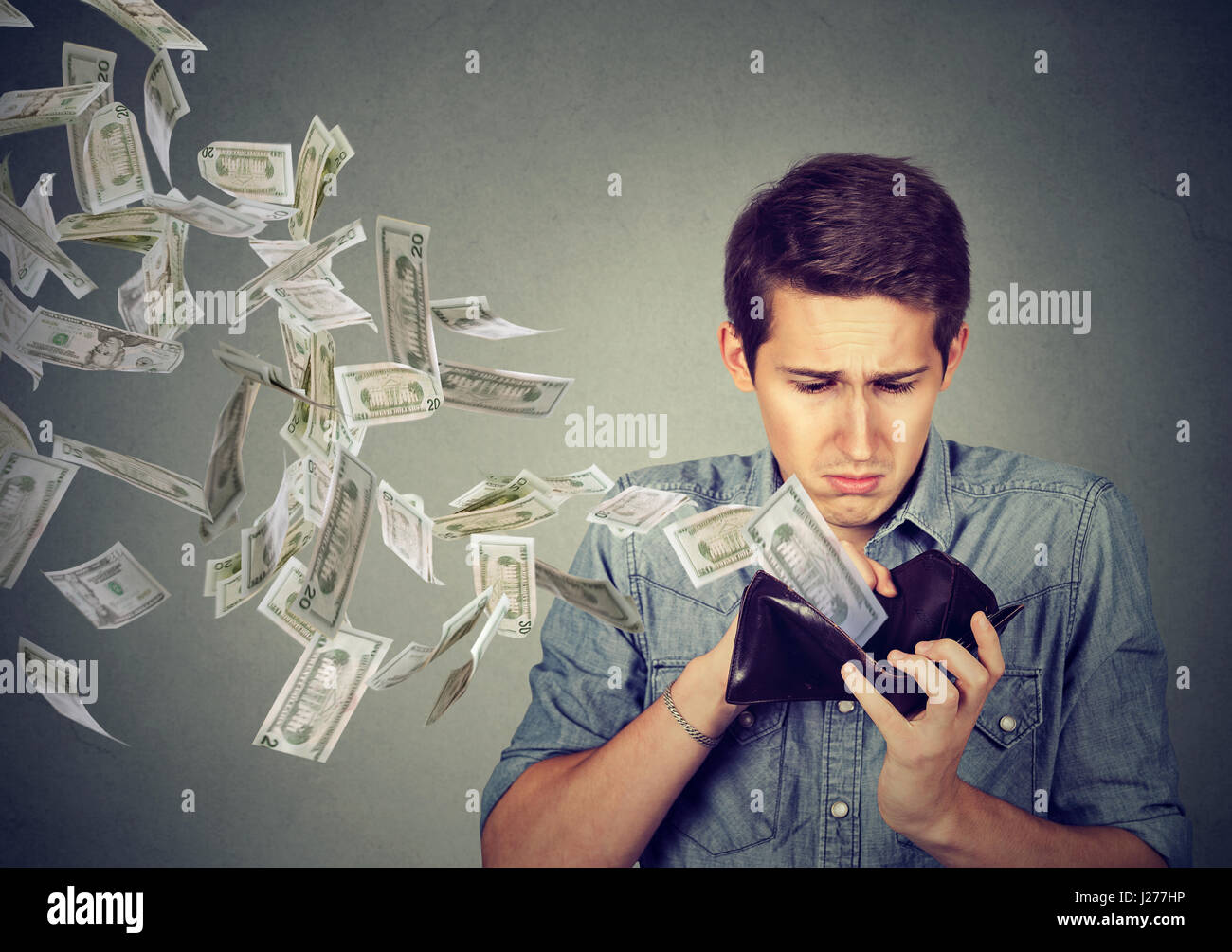 Sad man looking at his wallet with money dollar banknotes flying out ...